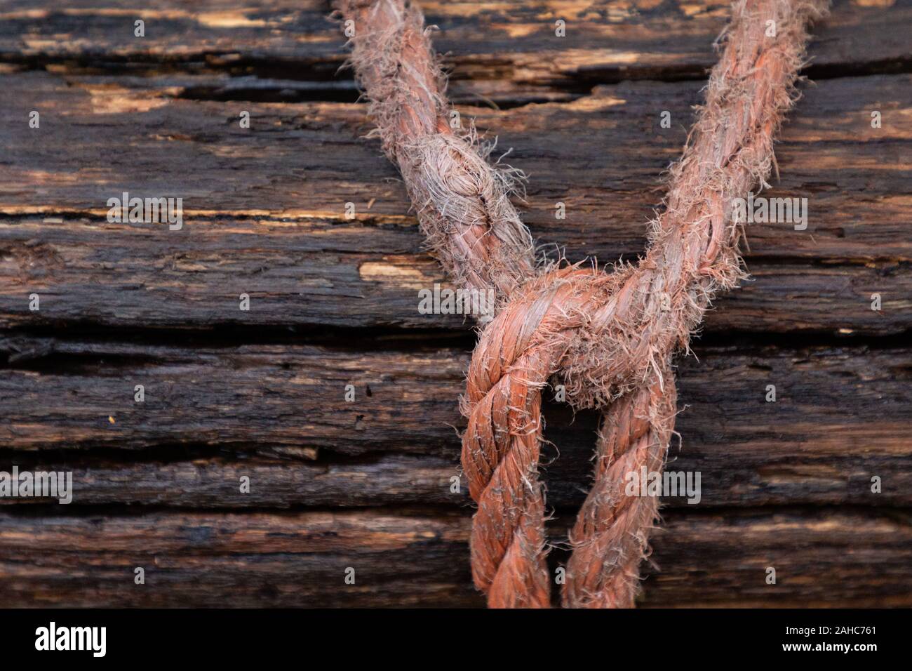 draped rope on a wet wooden post Stock Photo - Alamy