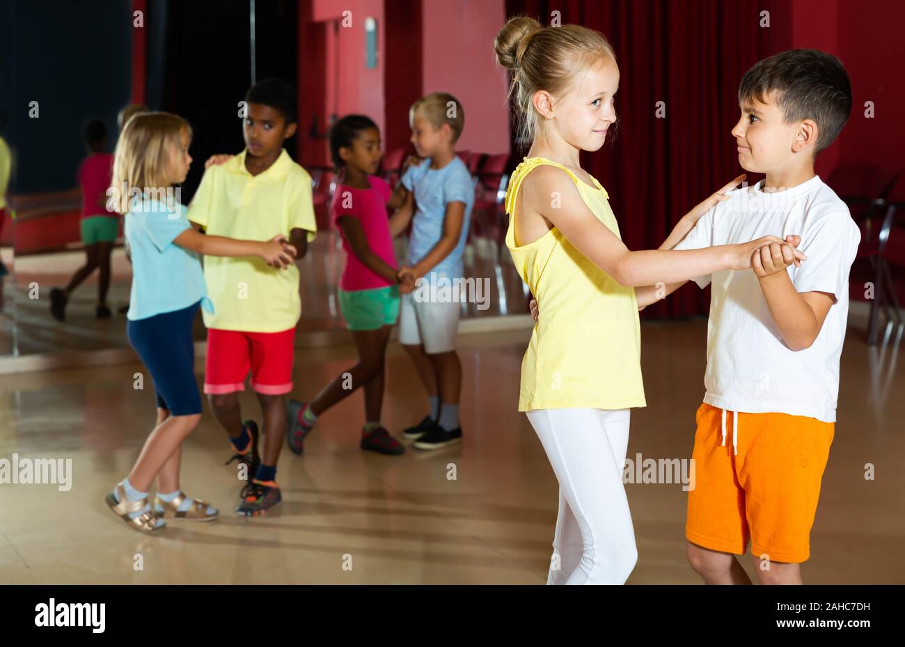 Group of laughing children dancing salsa dance in modern studio Stock ...