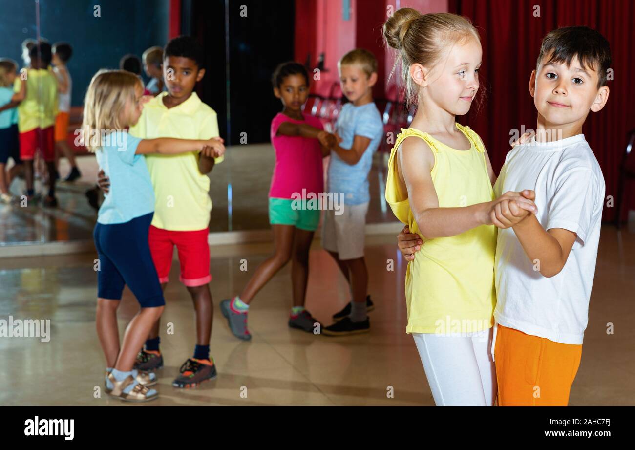 Group of glad smiling childrens trying dancing with partner in ...