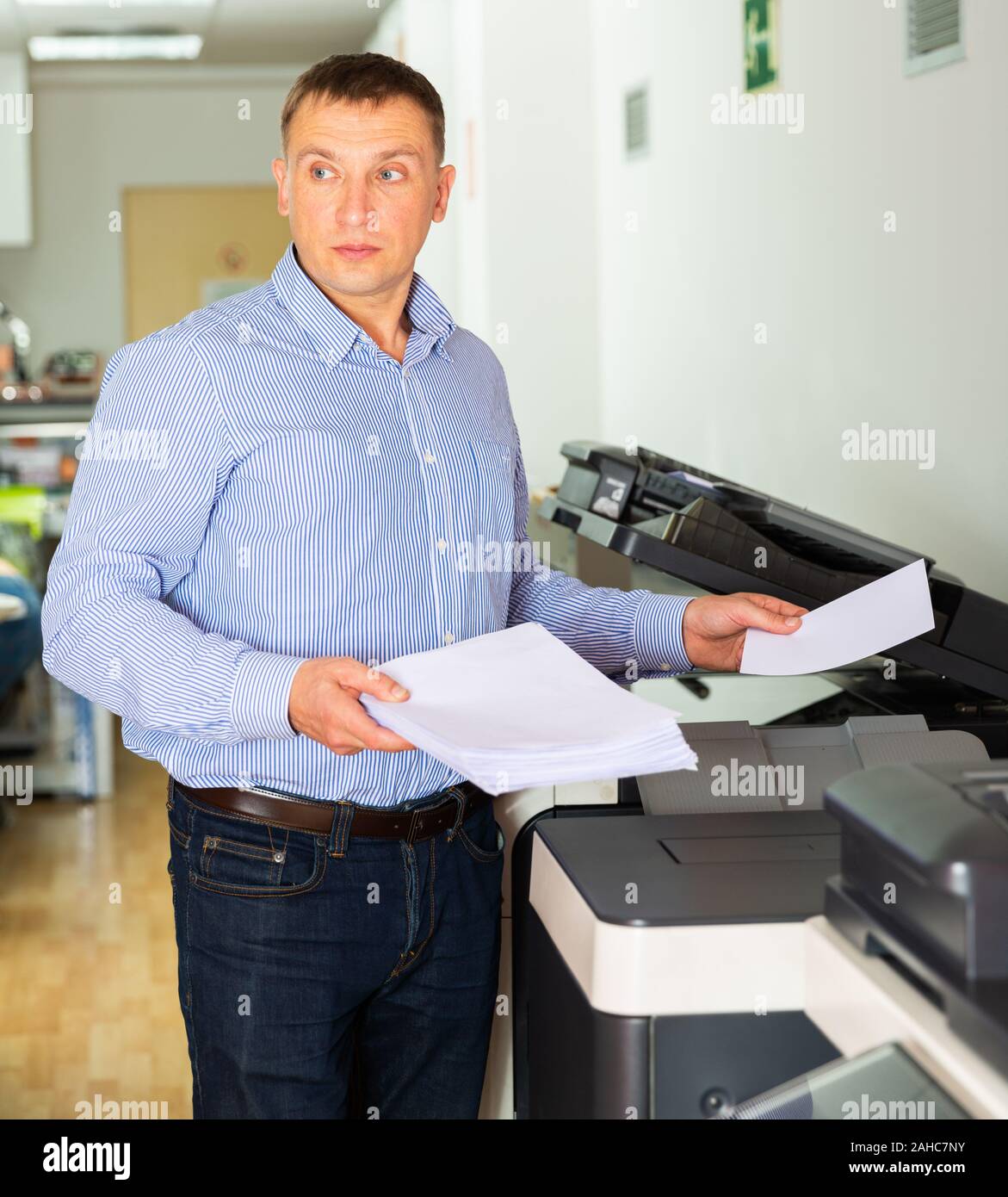 Office worker puts a stack of paper in the printer Stock Photo - Alamy