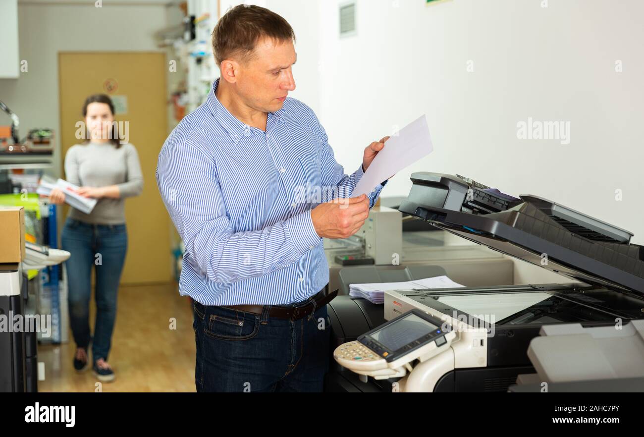 Worker is printing a file, document in the office room Stock Photo - Alamy