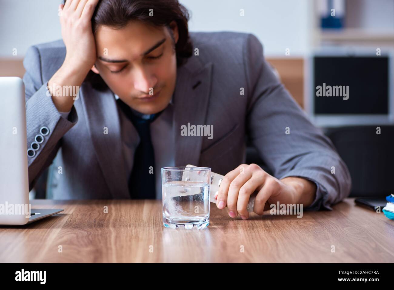 The sick male employee suffering in the office Stock Photo - Alamy