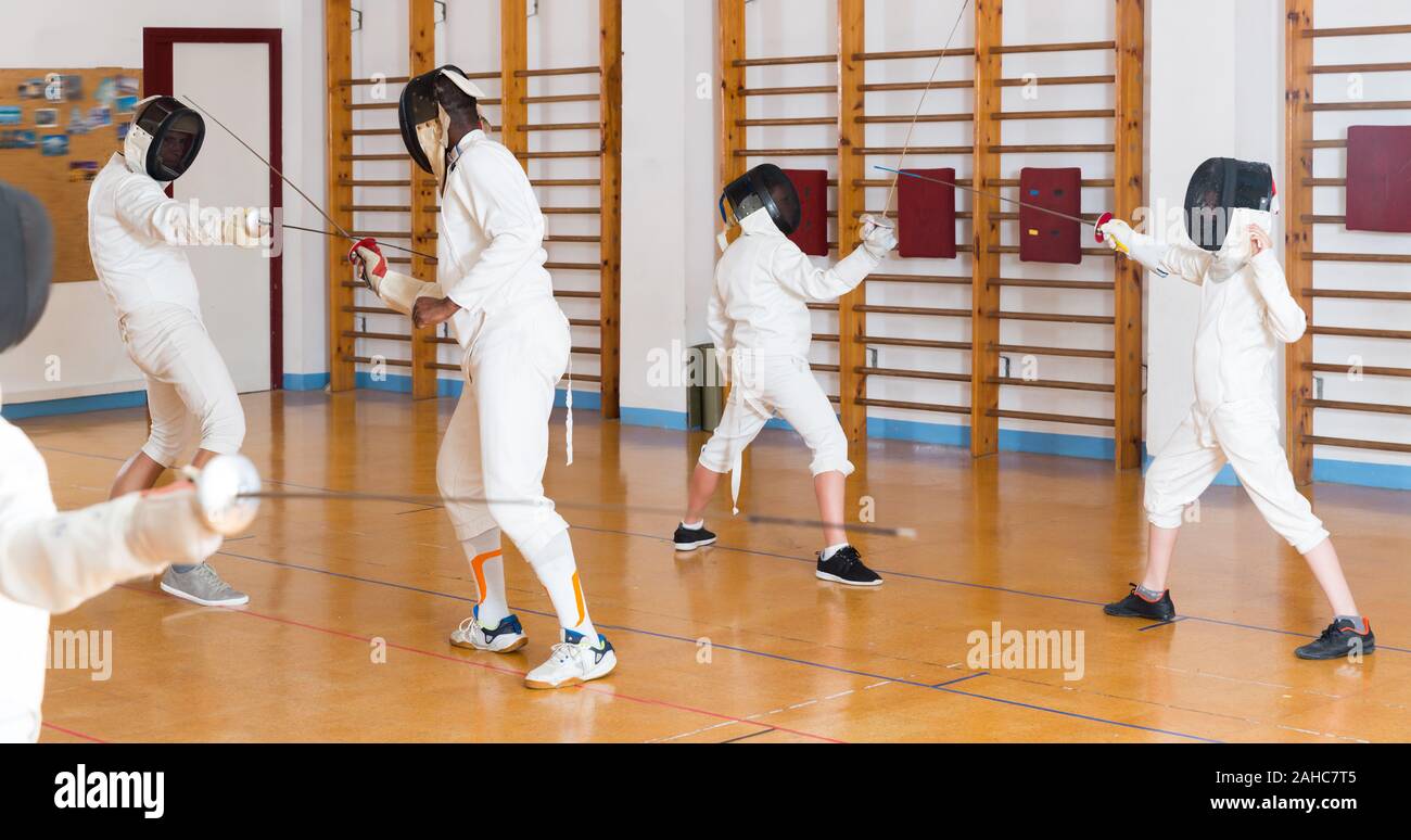 Nice group practicing effective fencing techniques in sparring in ...