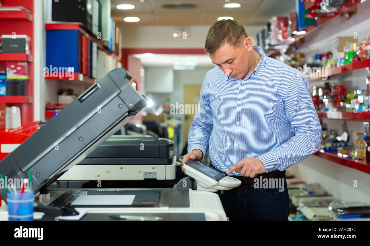 Worker is printing a file, document in the office room Stock Photo - Alamy