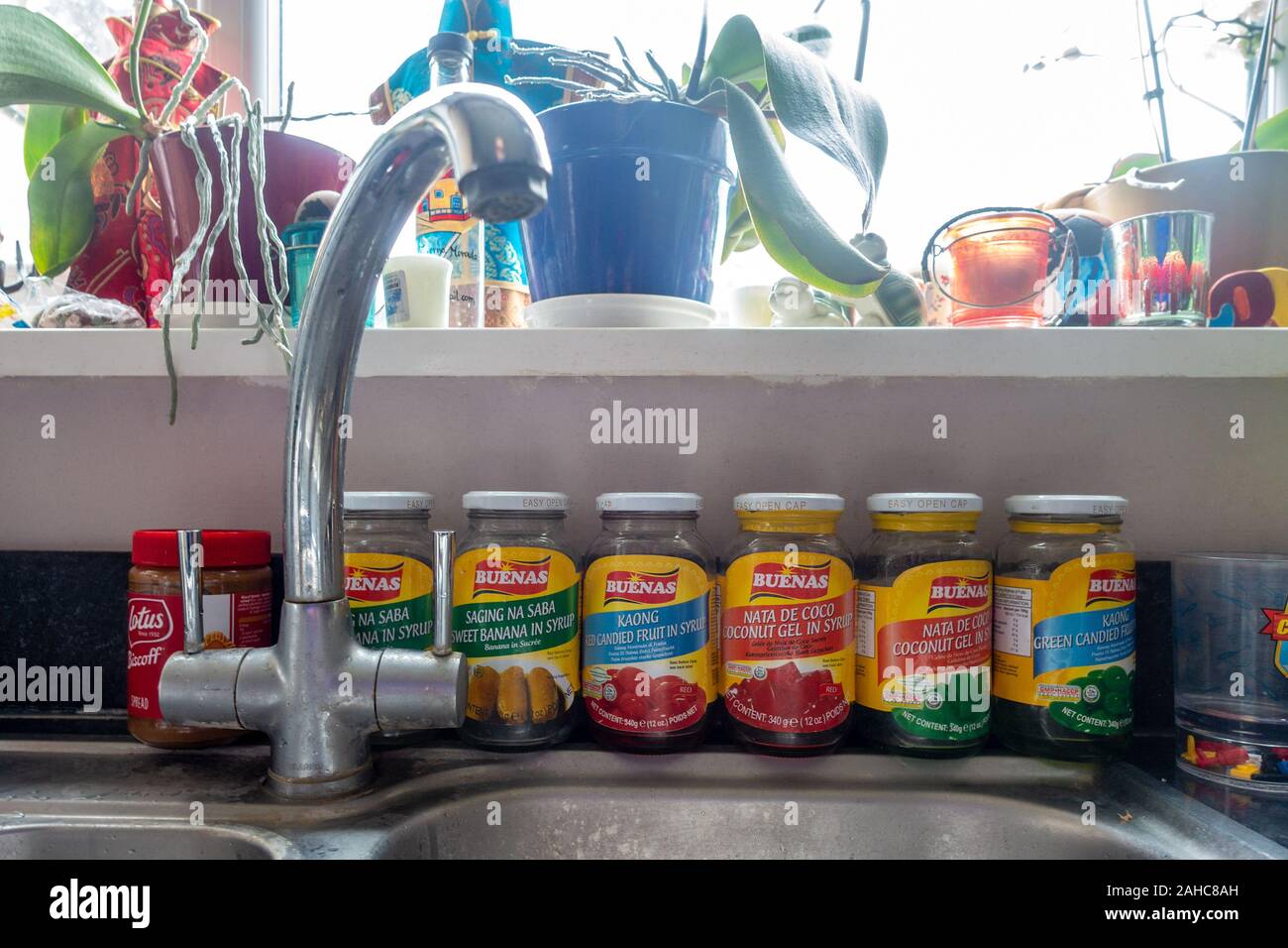 Empty glass jars lined up behind the kitchen sink Stock Photo - Alamy