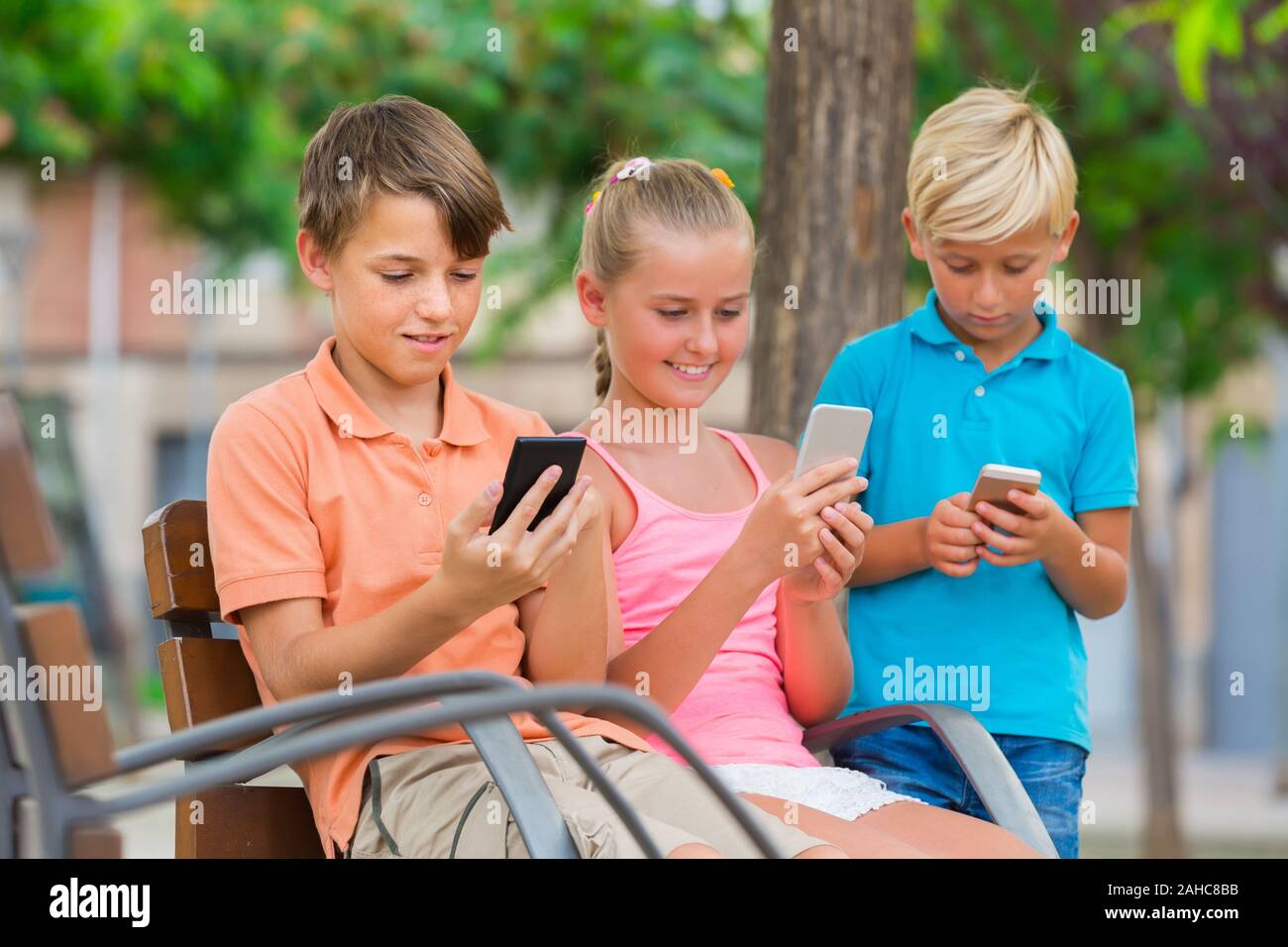 positive french children are chatting in phones in the playground Stock ...
