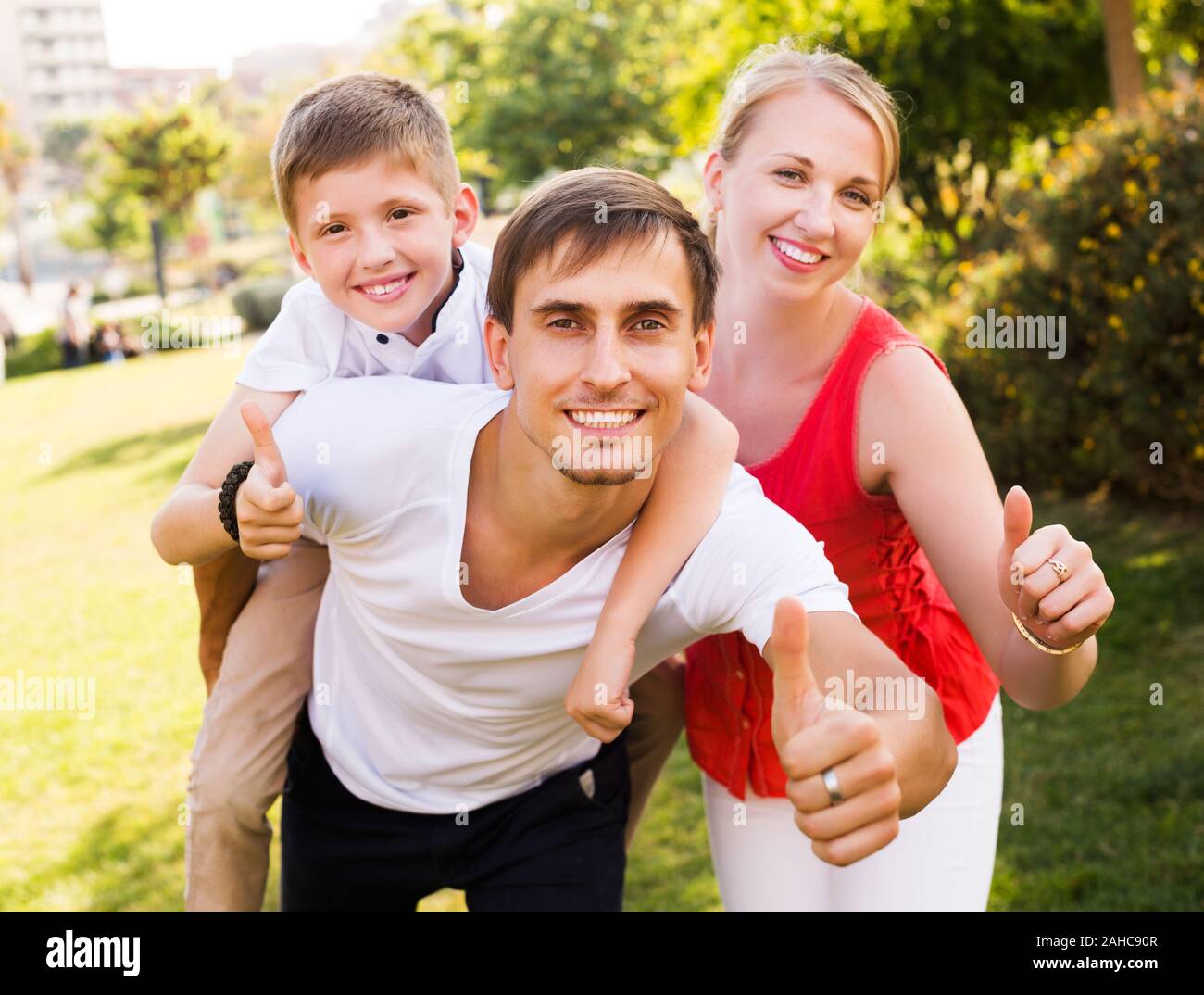 Happy young parents with boy in school age having fun and showing ...