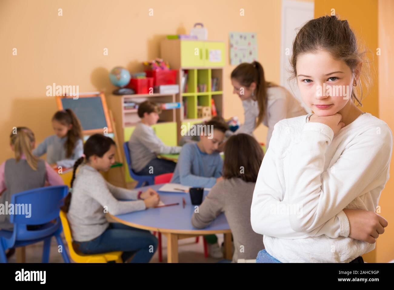 Portrait of sad girl and children drawing in classroom Stock Photo - Alamy