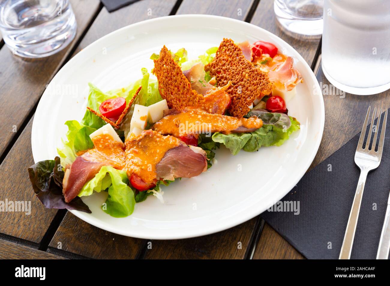 Traditional French cuisine, Basque salad with sliced smoked bacon ...