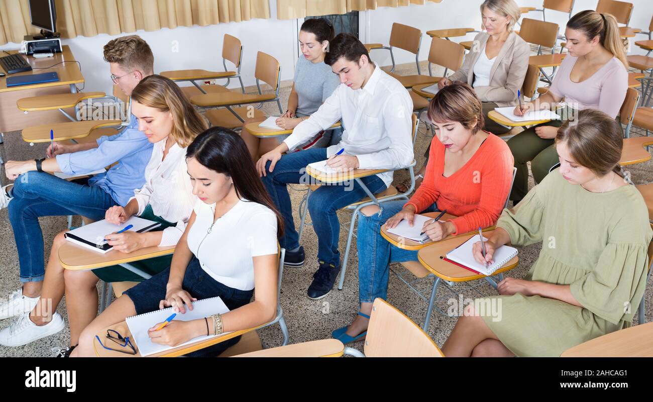 Small group of students attentively listening to lecture in a classroom ...