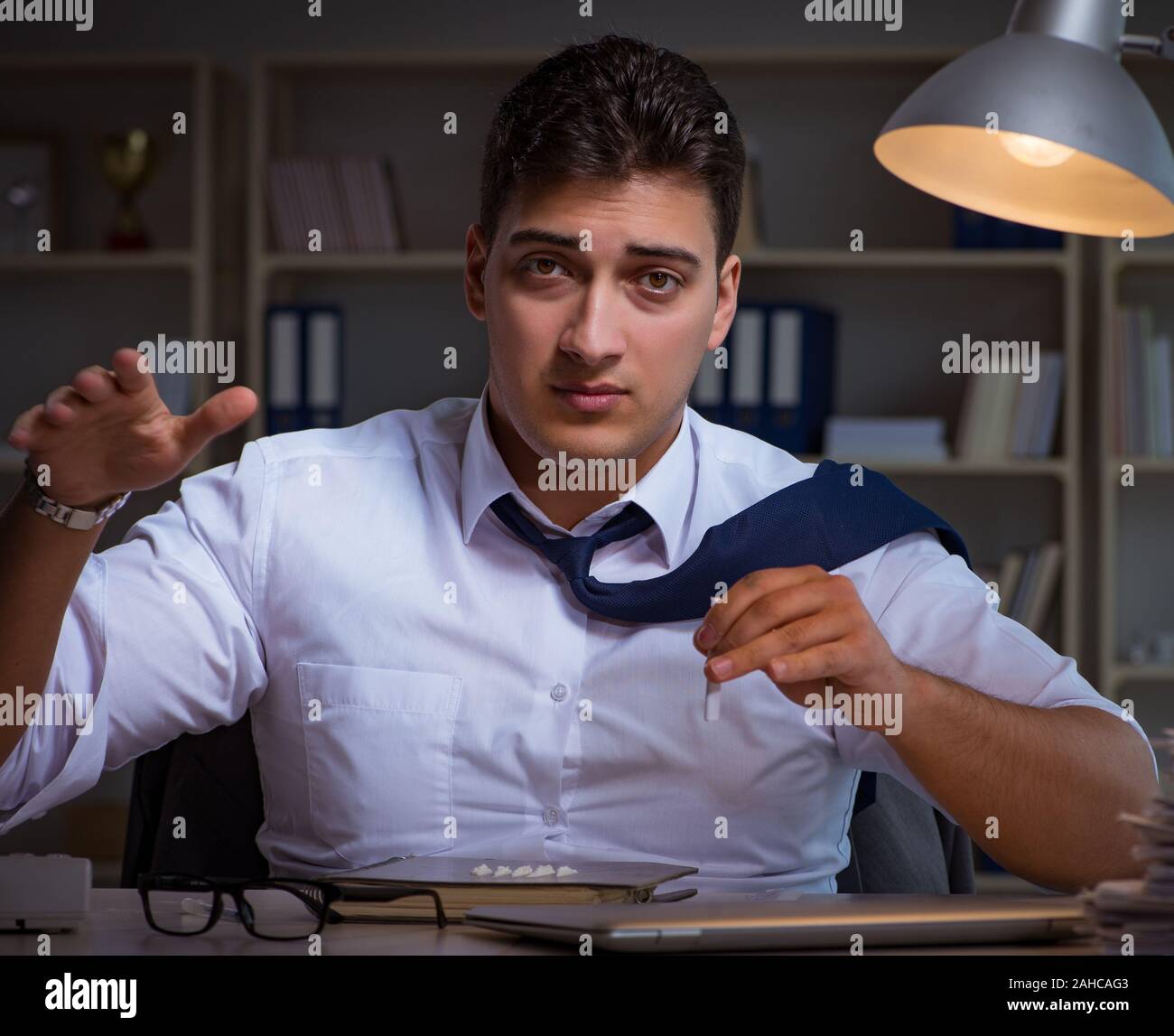 The businessman staying late in office for drugs Stock Photo - Alamy