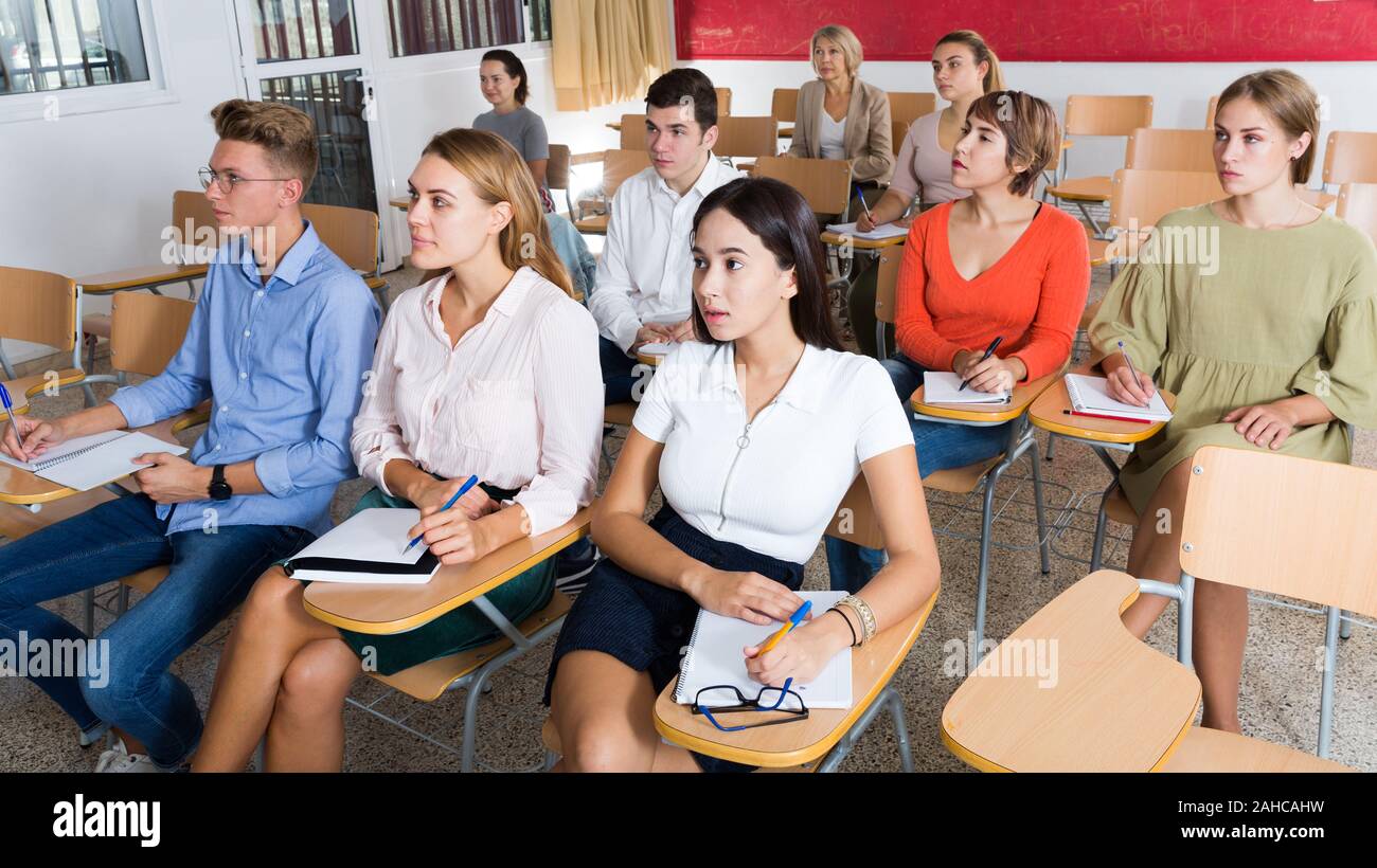 Small group of students attentively listening to lecture in classroom ...
