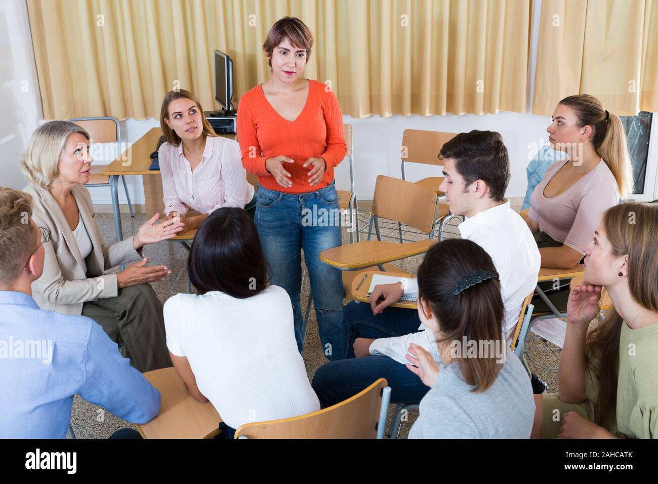 Confident girl talking to student group during brainstorming while ...