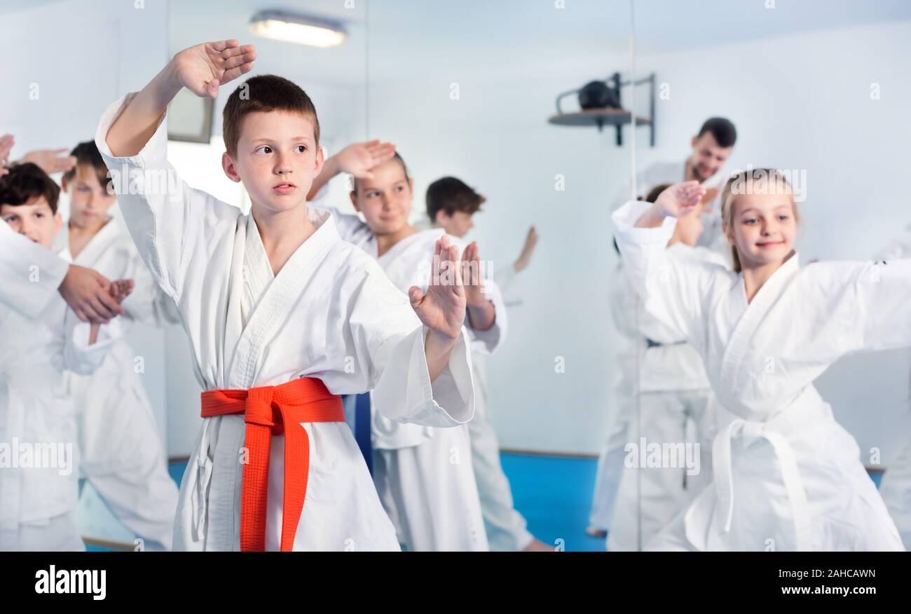 Children trying new martial moves in a practice during a karate class ...