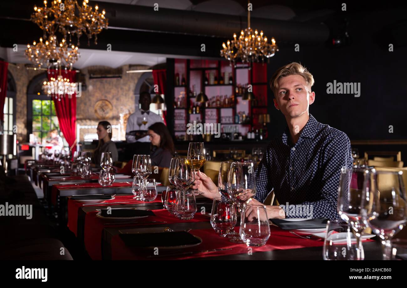 Single young man with glass of wine sitting in luxury restaurant Stock ...