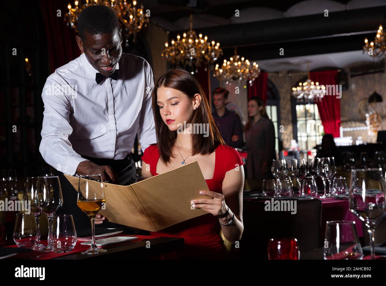 African-american waiter receiving order from guest in fashionable ...