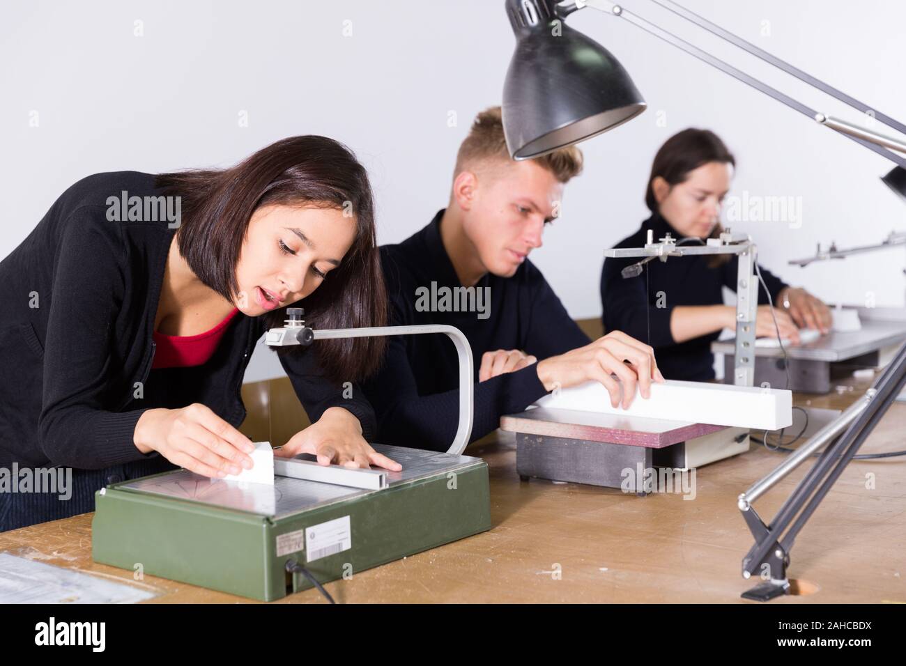 Female student of architecture faculty using scroll saw while engaged ... Female student of architecture faculty using scroll saw while engaged ...