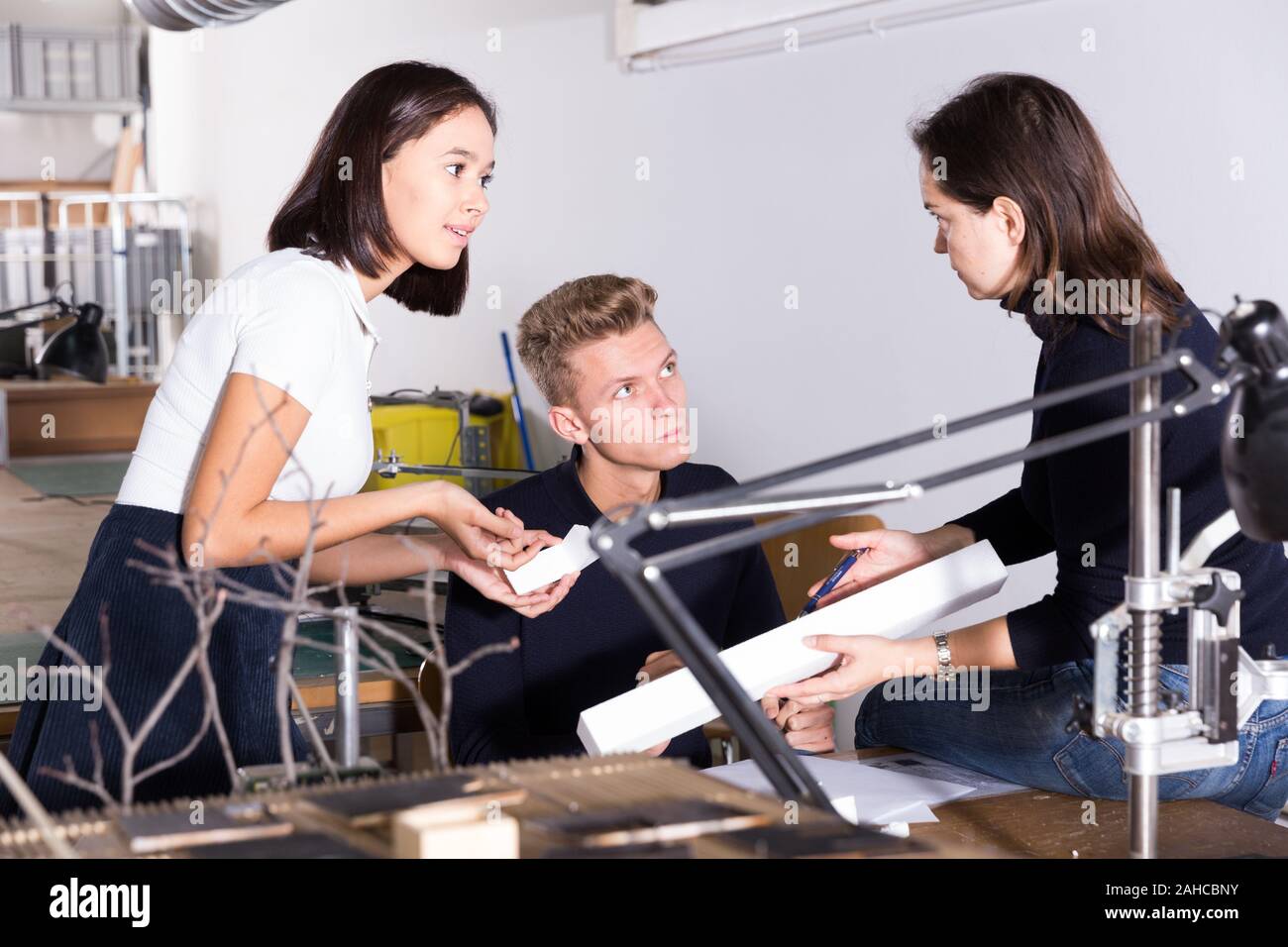 Students and teacher of architecture faculty discussing details of ...