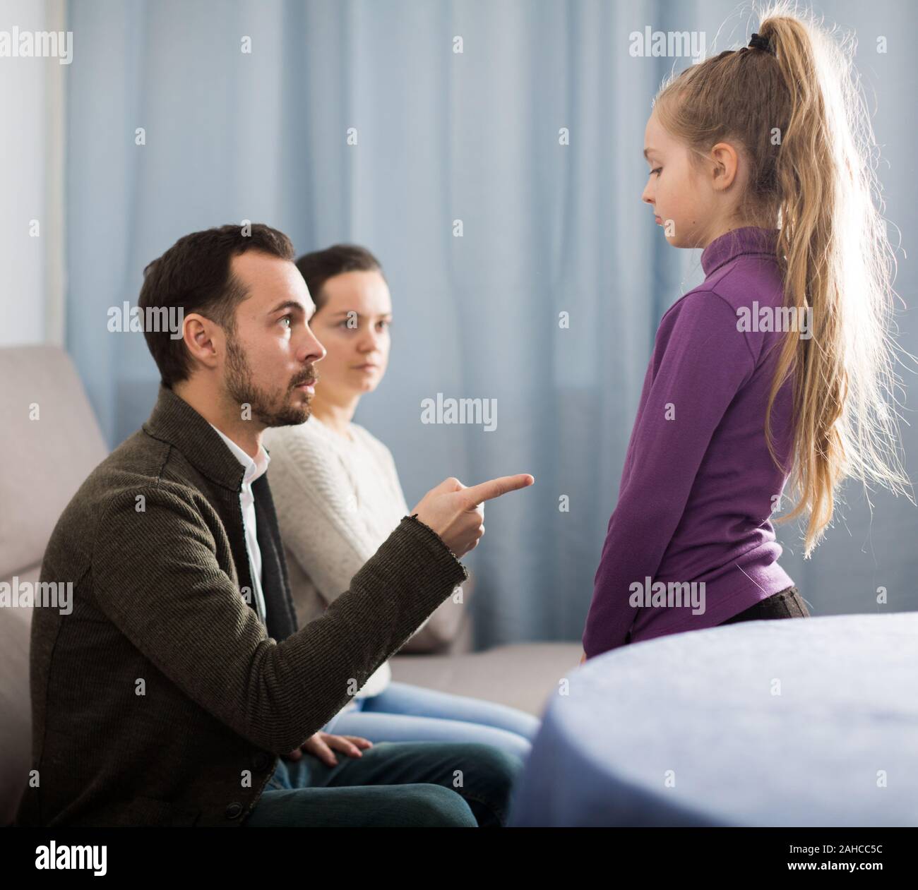 Father and mother telling off their daughter for disobedience Stock ...