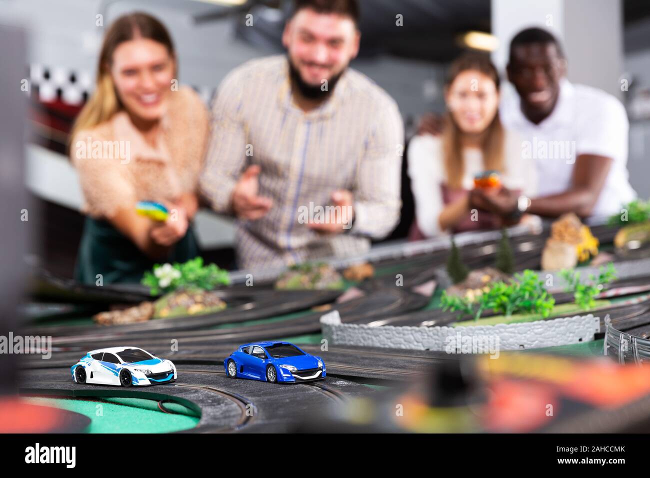 Models of race cars on the track in game room, team of emotional ...