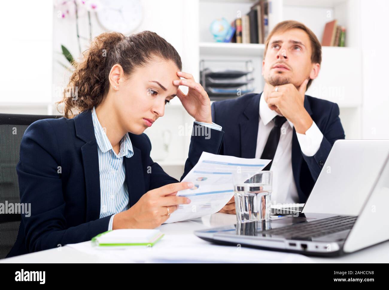 Two depressed business male and female assistants making mistake in ...