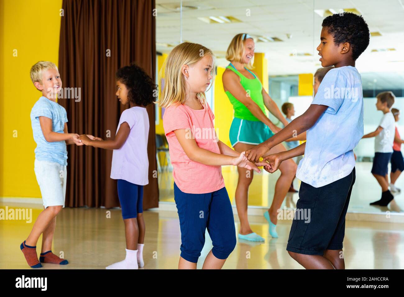 Group of cheerful positive smiling children practicing vigorous jive ...