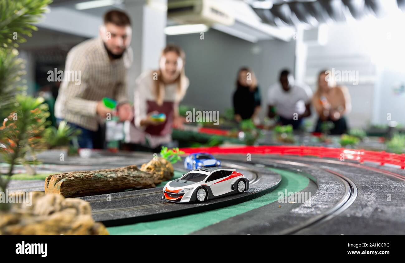 Toy remote control racing bright cars on the track and enthusiastic ...