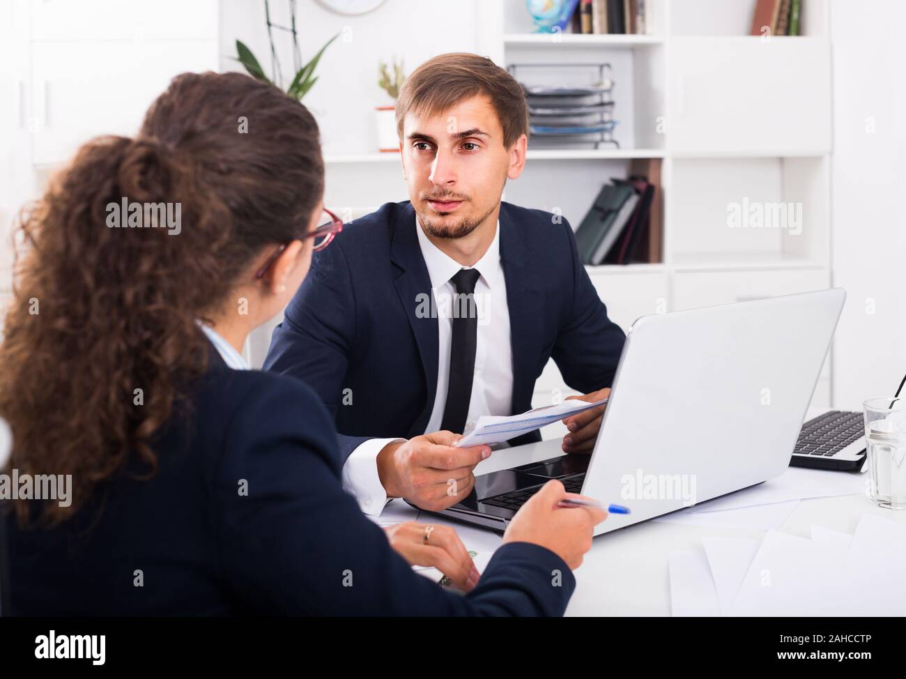 portrait of concentrated business man sitting with computer in office ...