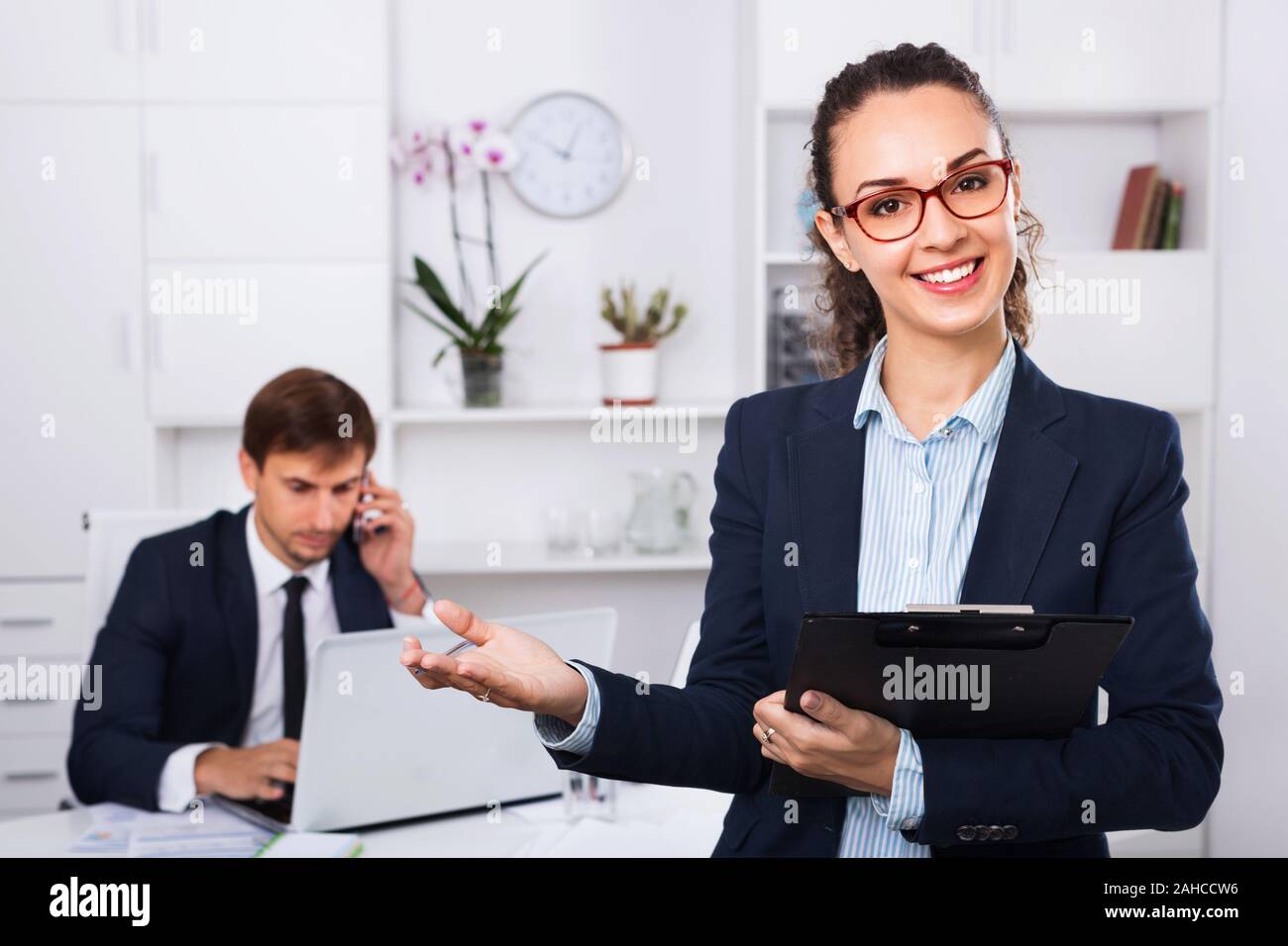 Glad positive business female secretary having cardboard in hands and ...