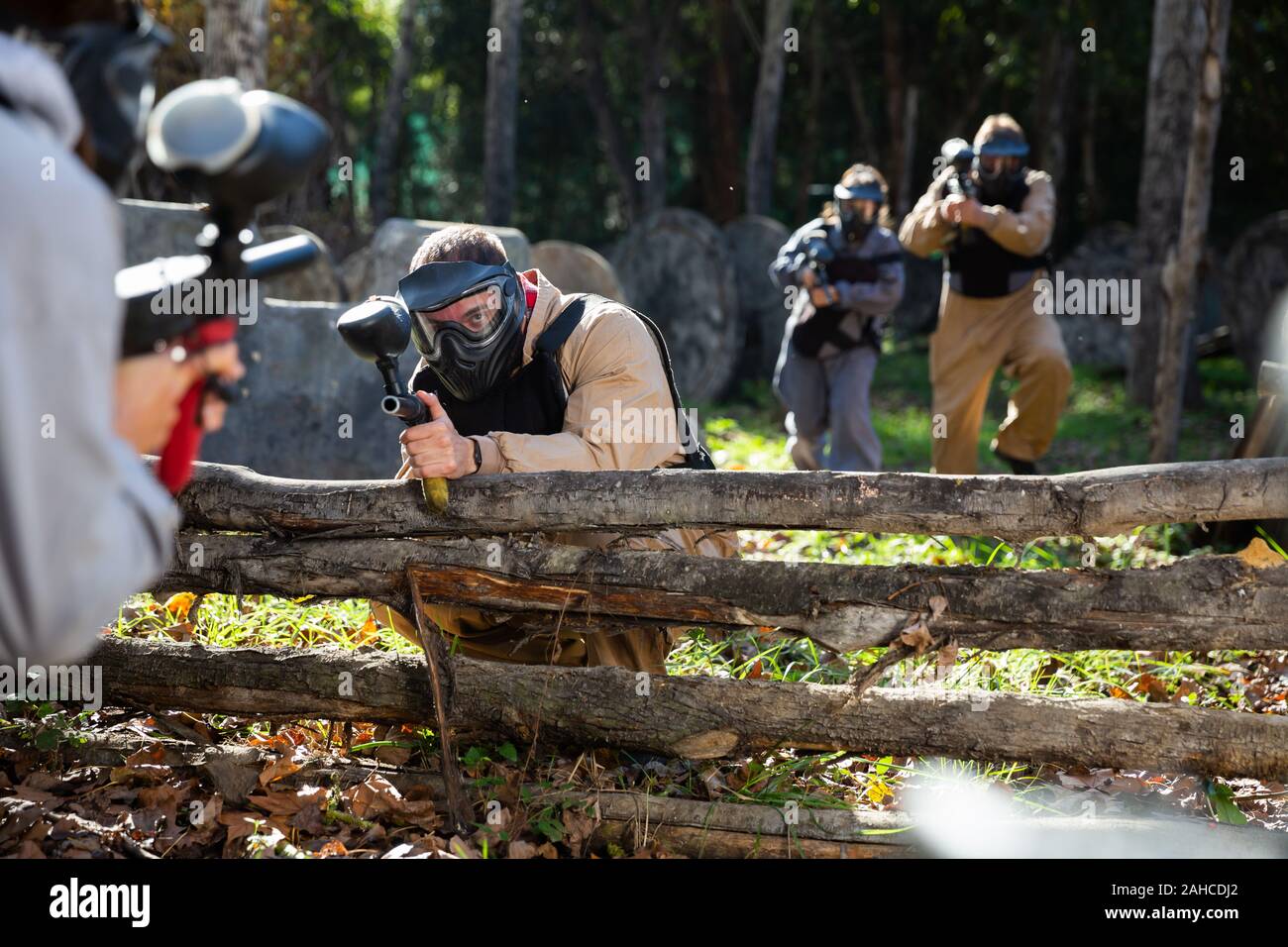 Portrait of team of adults playing on paintball battlefield outdoor ...