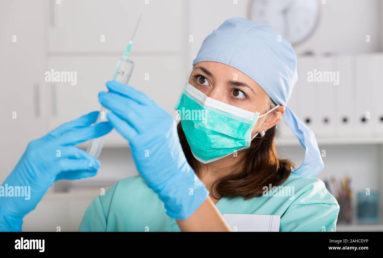 Professional nurse young woman making injection in modern hospital ...
