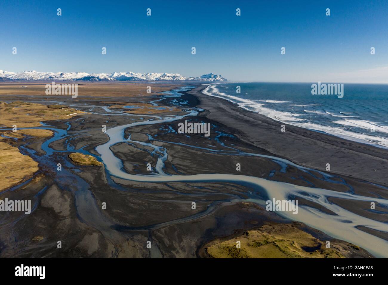 Aerial view of patterns of Icelandic rivers flowing into the ocean ...