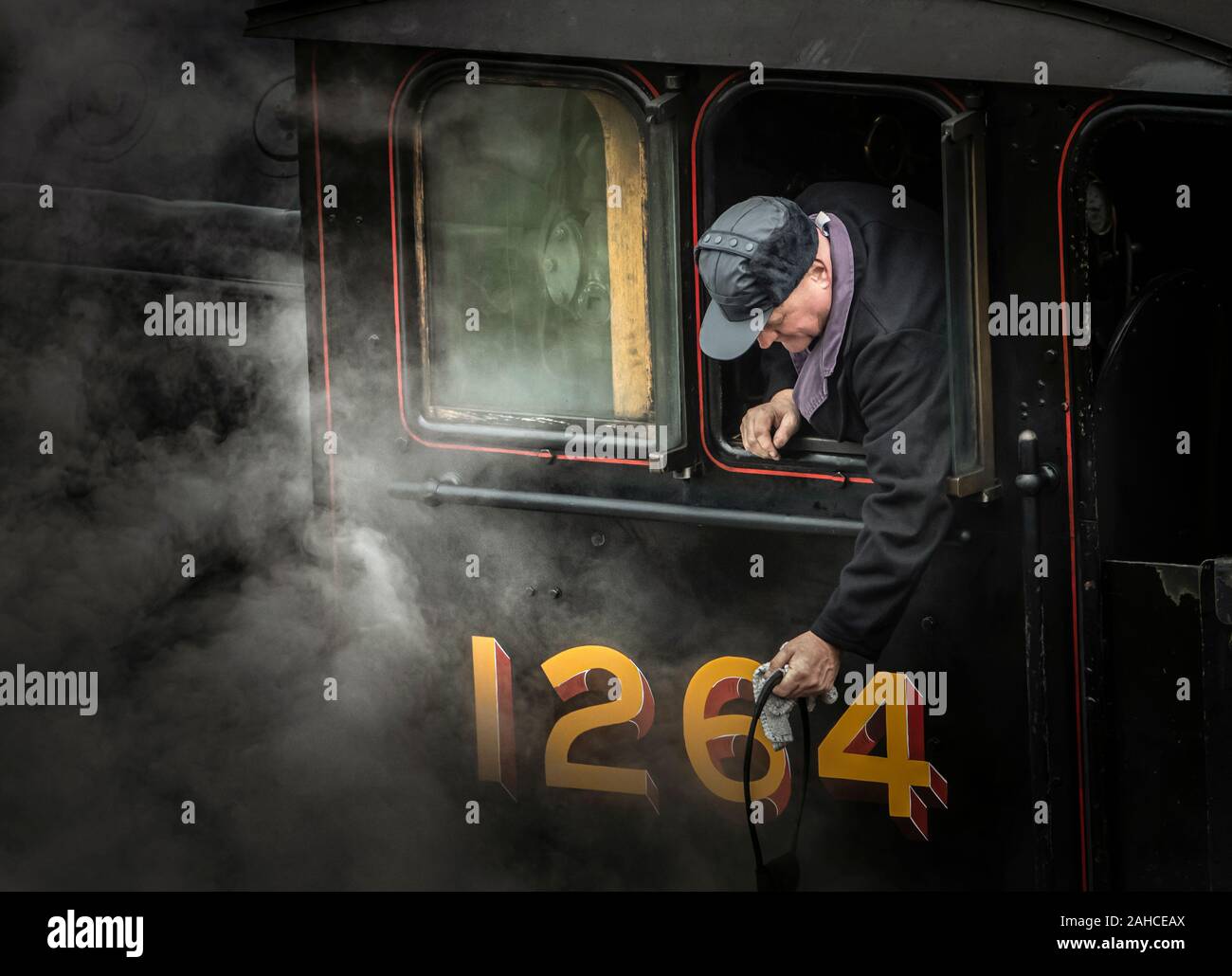 A man leans out of a LNER B1 1264 locomotive on the North Yorkshire ...