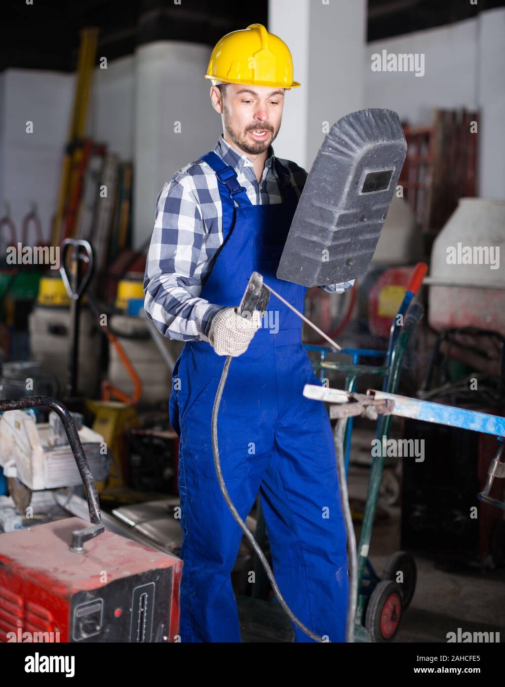 Male worker is starting to work with welding machine at workshop Stock ...