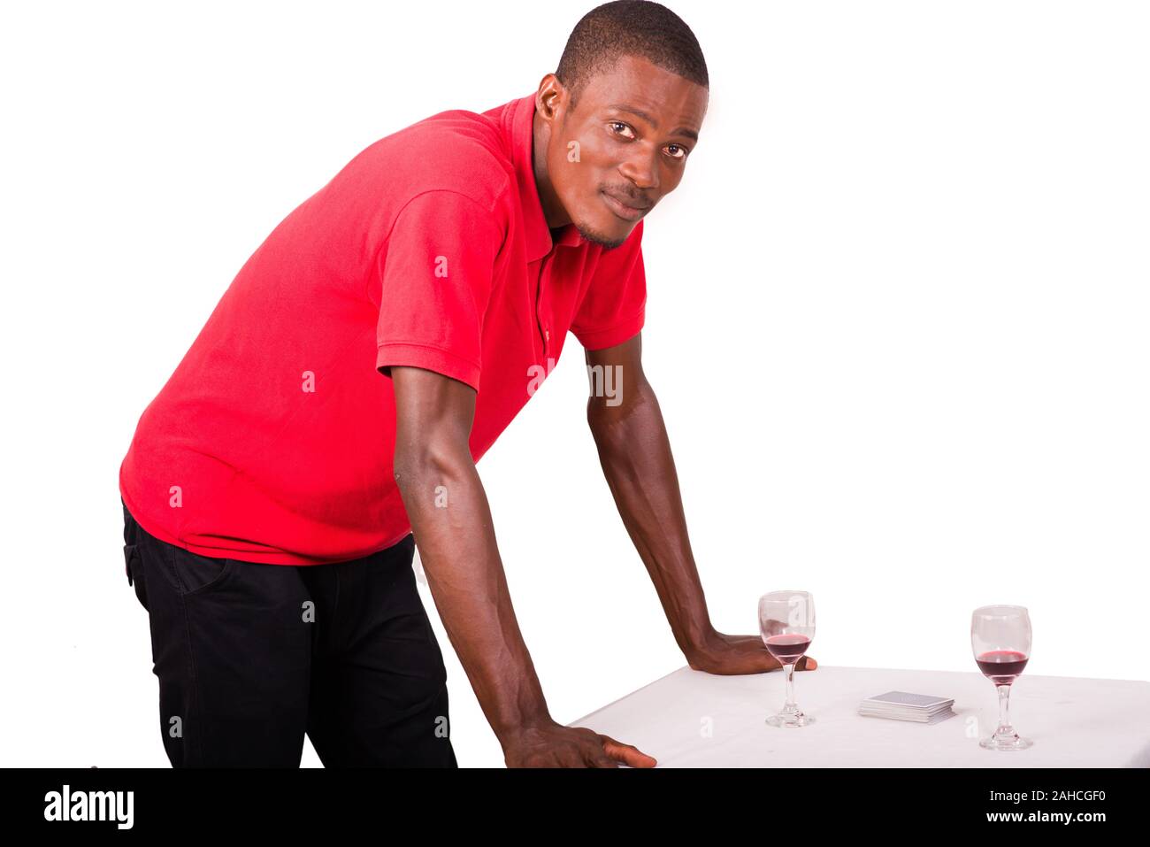 businessman leaning alone against a table with two glasses of wine in ...