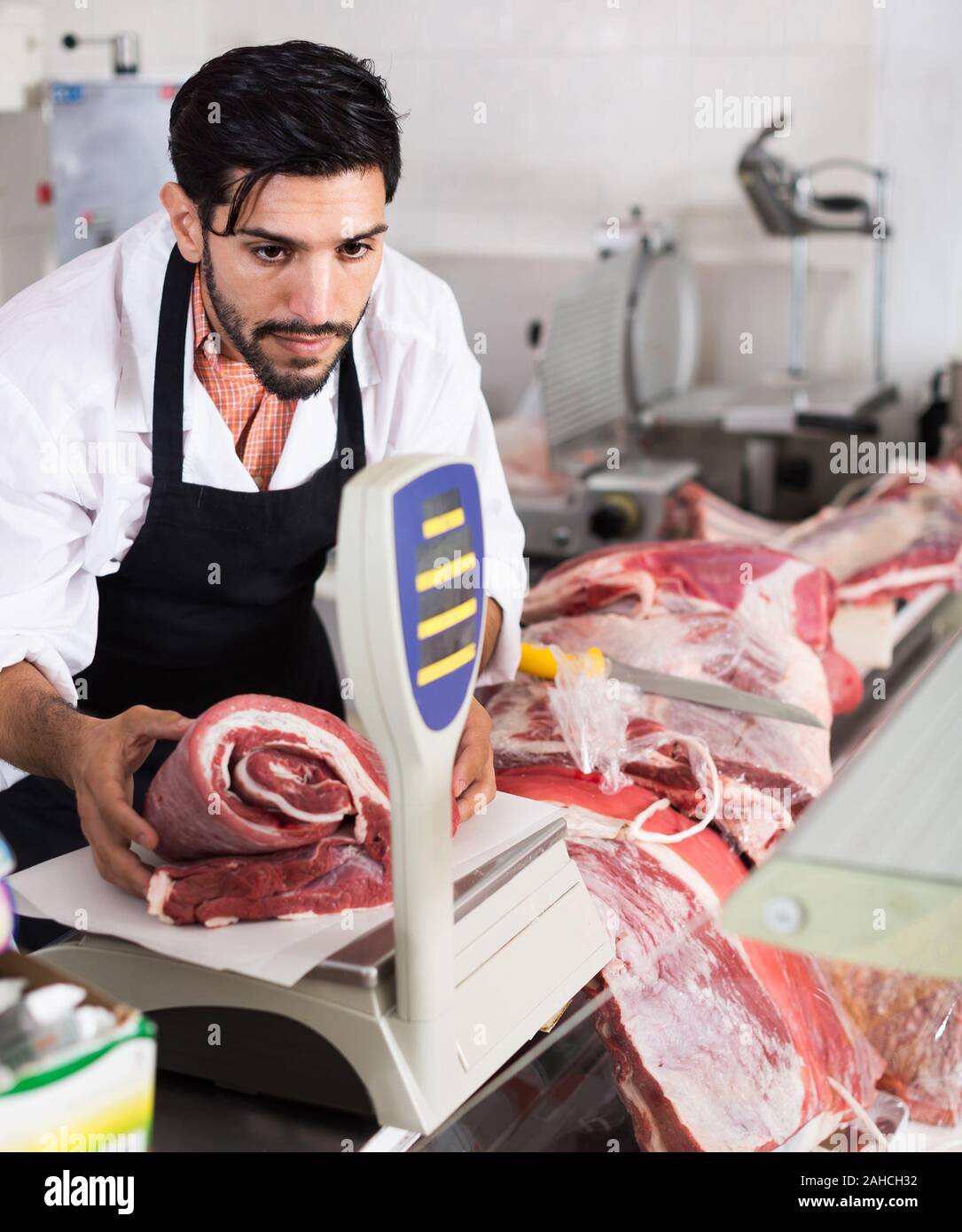 positive greek man butcher is weighing meat in the market Stock Photo ...