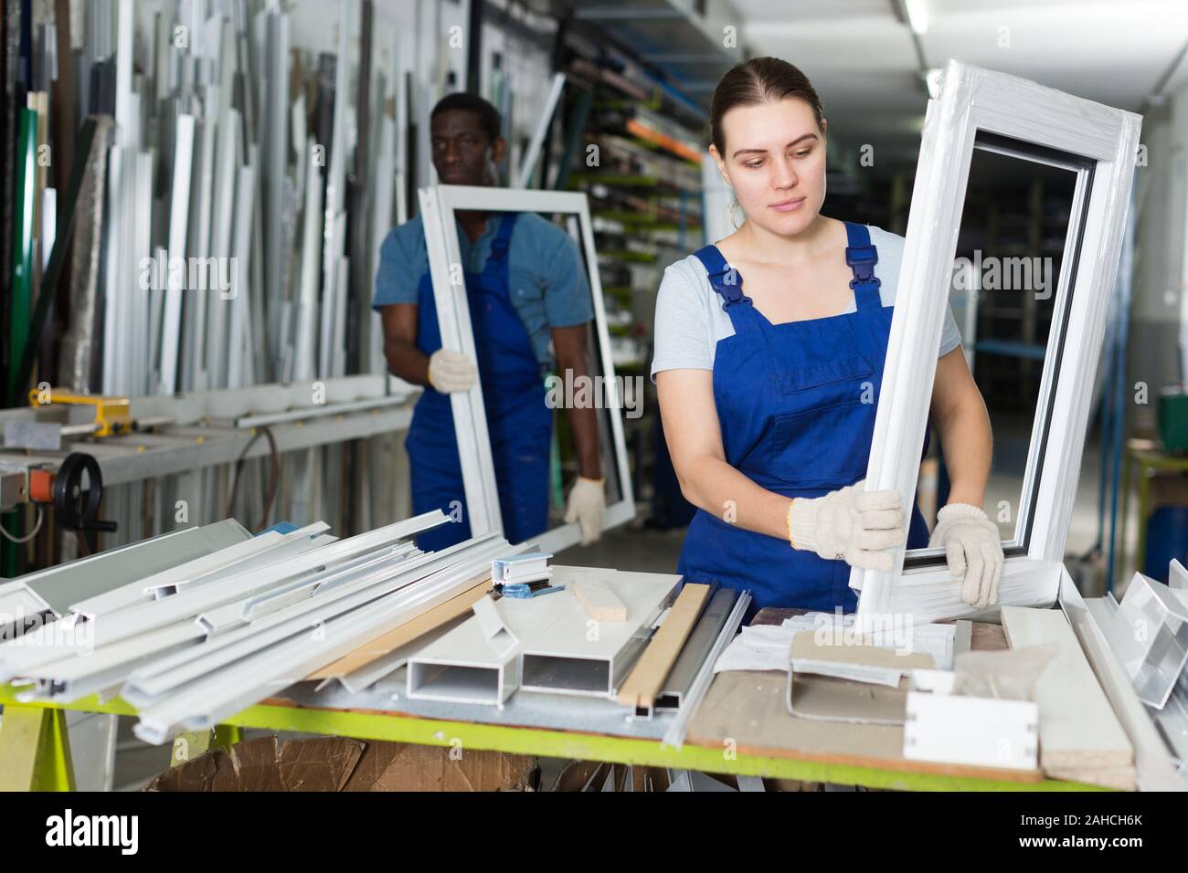 Female master is working with window frame in the window workshop Stock ...