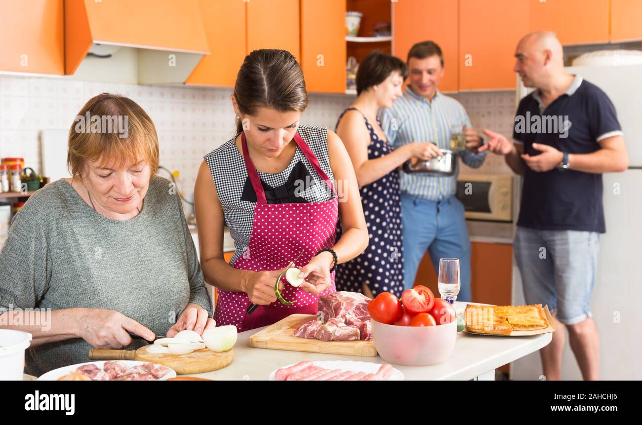 Positive people cooking together in kitchen Stock Photo - Alamy