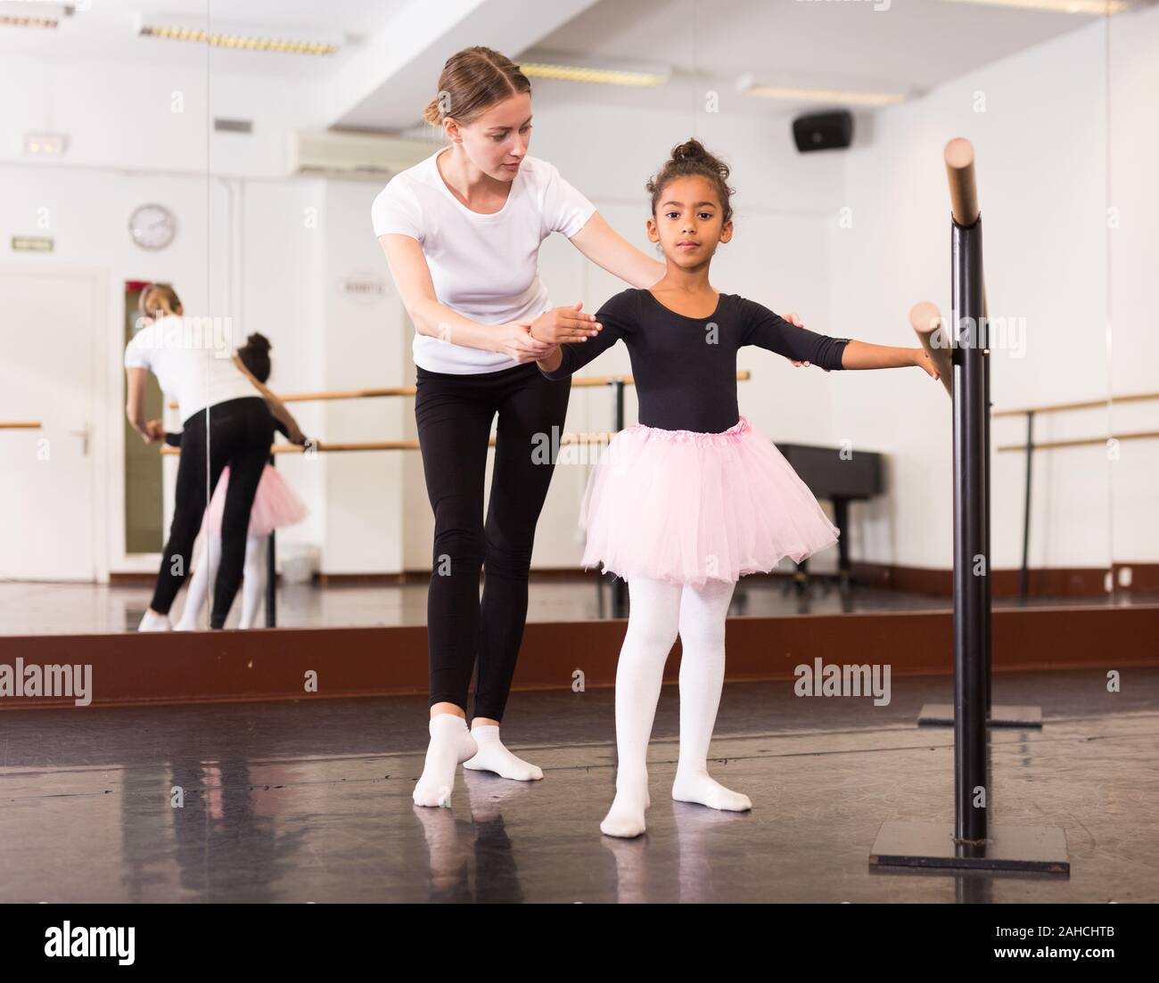 Little ballerina practicing choreographic elements with help of ballet ...