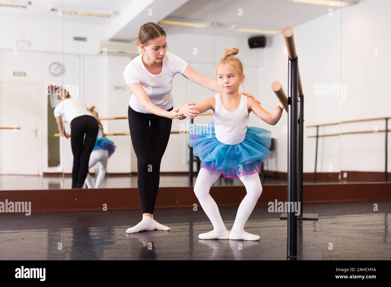 Little ballerina practicing choreographic elements with help of ballet ...