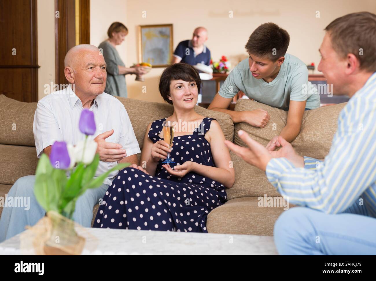 Happy large family gathered in parental home for family party, talking ...
