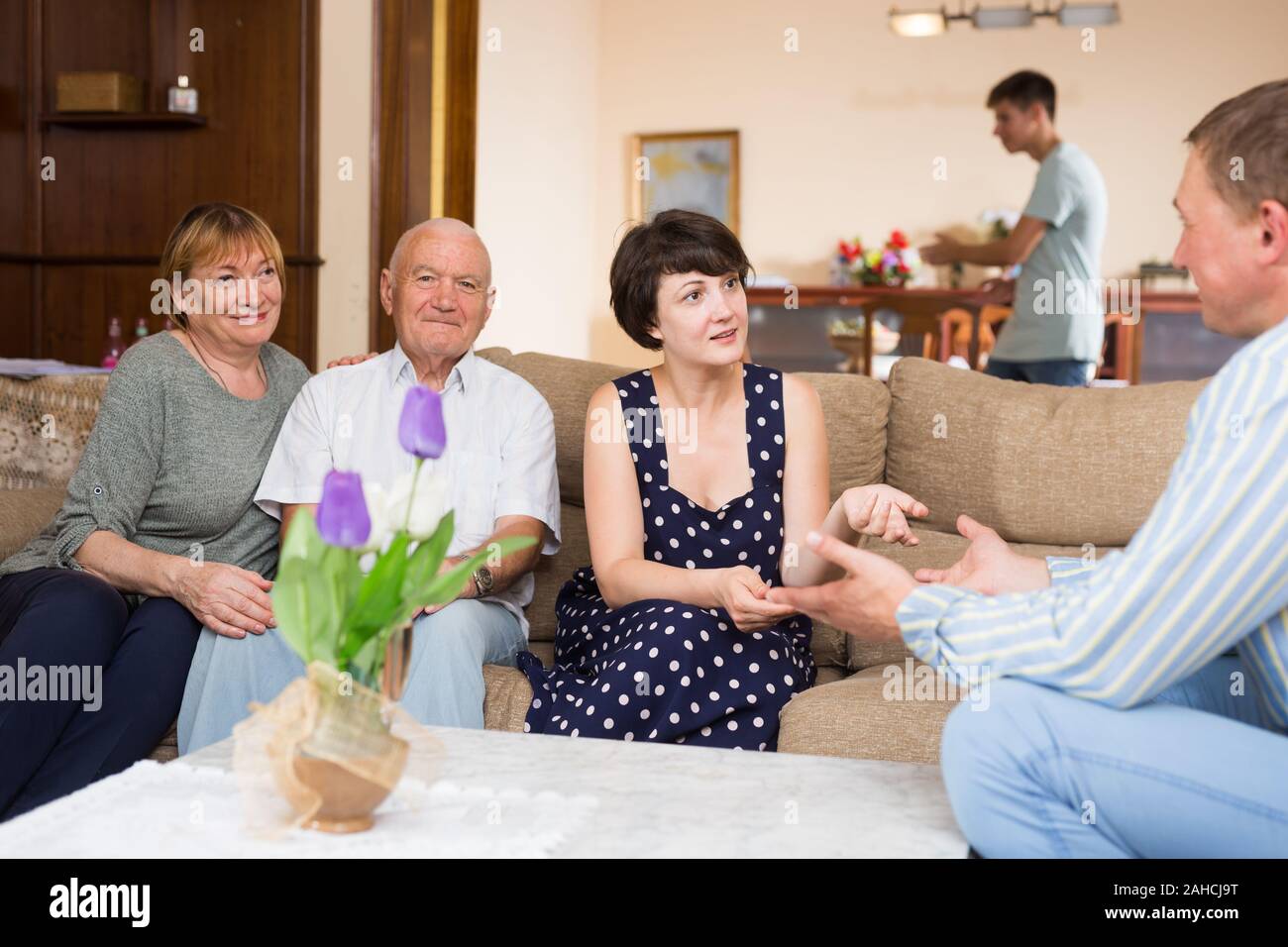 Happy large family gathered in parental home for family party, talking ...