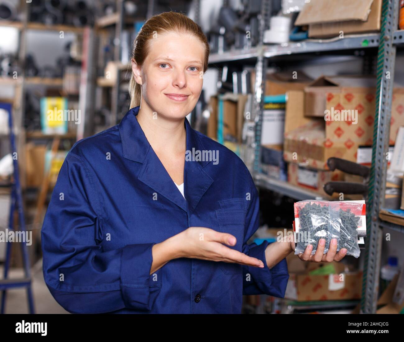 Young female worker ib uniform showing construction materials in modern ...