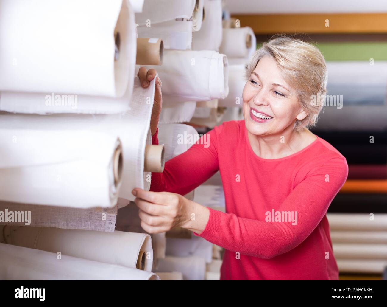 Blonde woman choosing textiles hi-res stock photography and images - Alamy