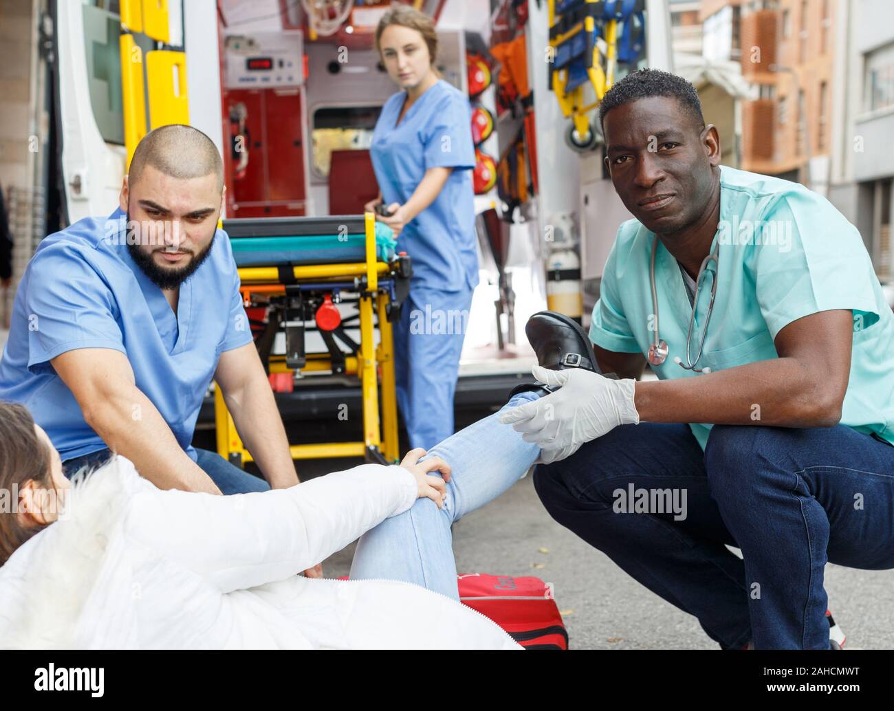Ambulance team providing medical care to injured female patient near ...