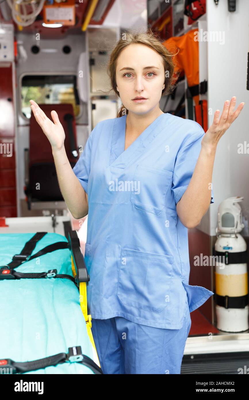 Portrait of female emergency doctor throwing up her hands in ambulance ...