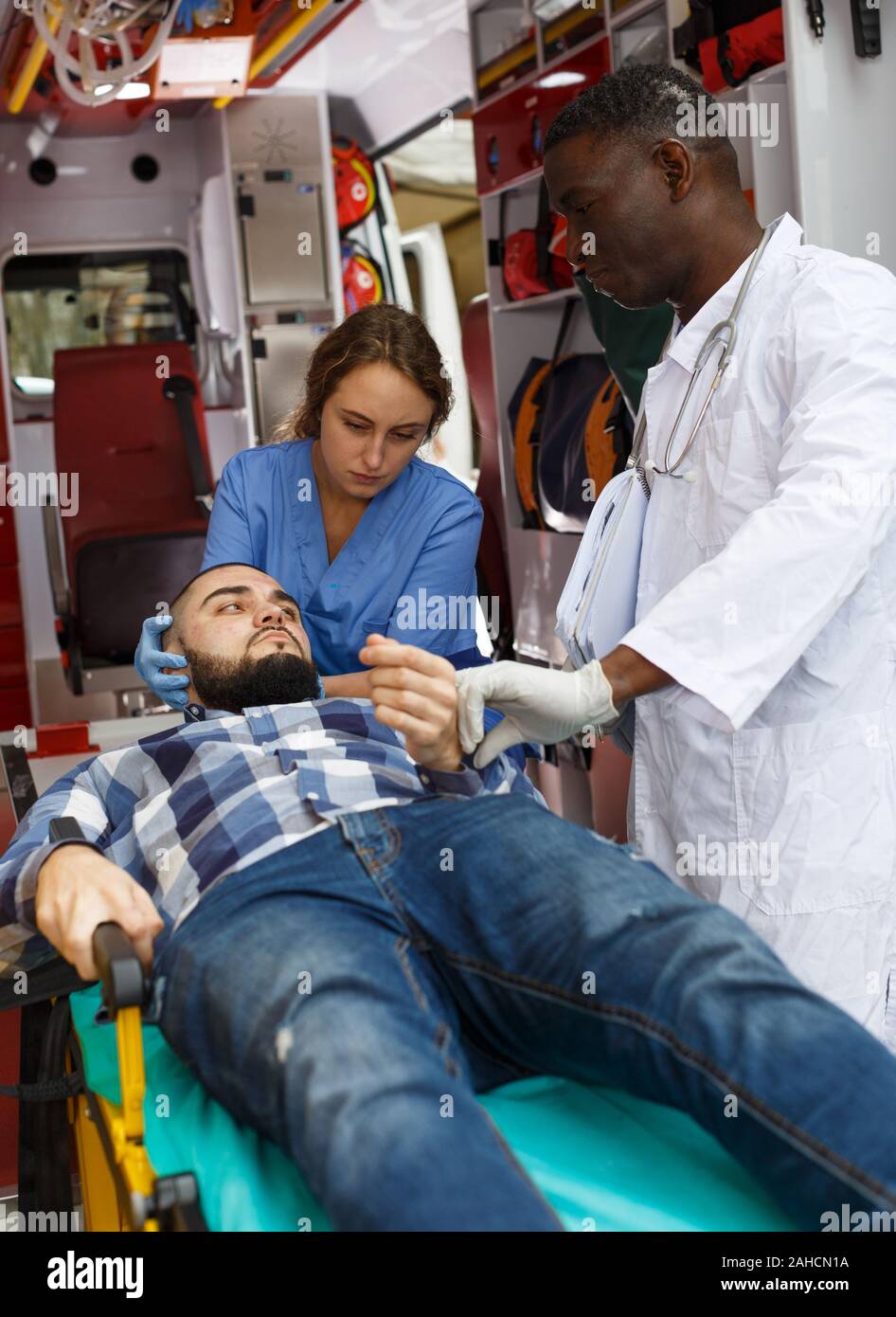 Ambulance team providing medical care to patient on stretcher in ...