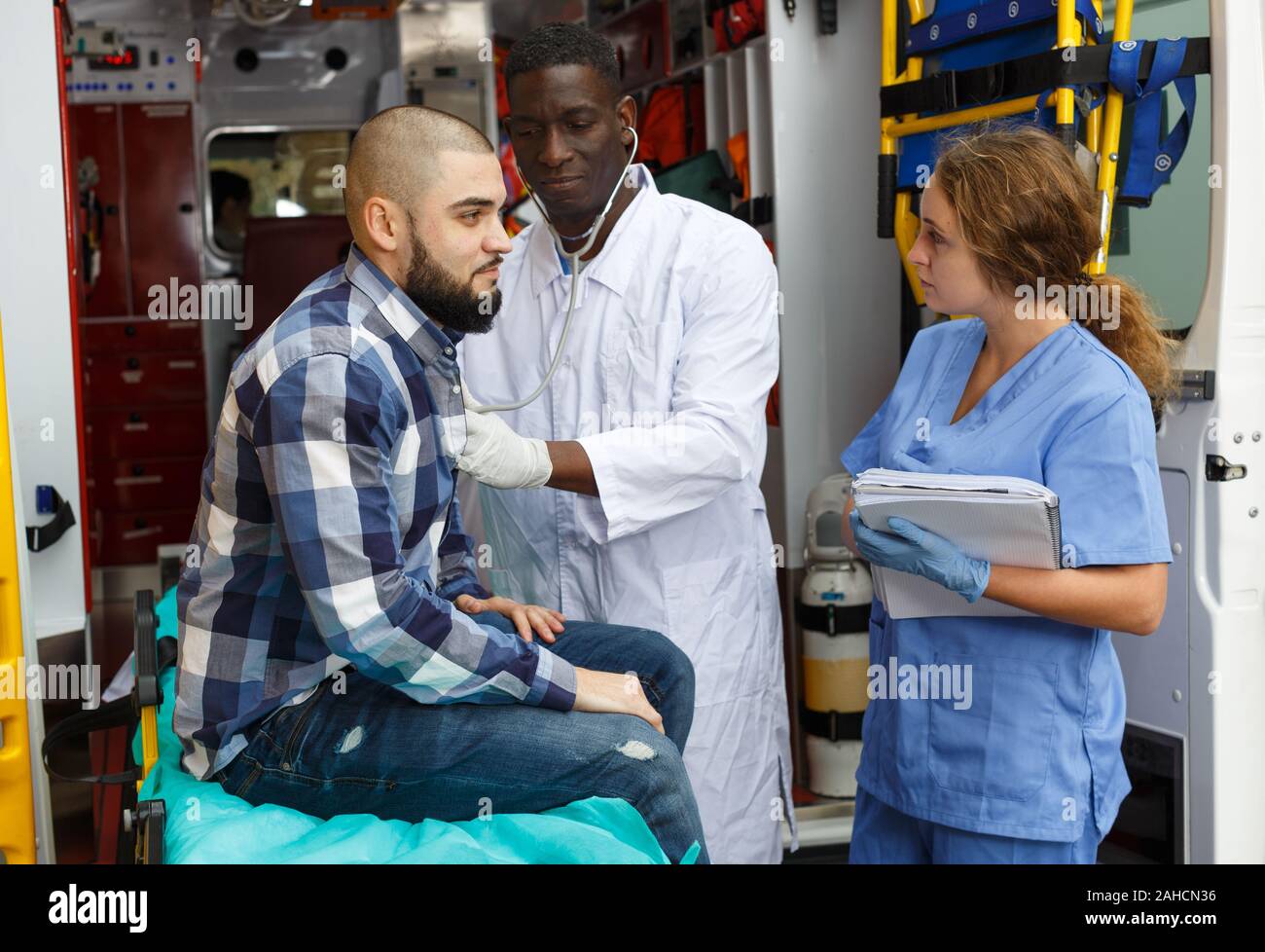 Paramedic team providing first aid to man in ambulance auto Stock Photo ...