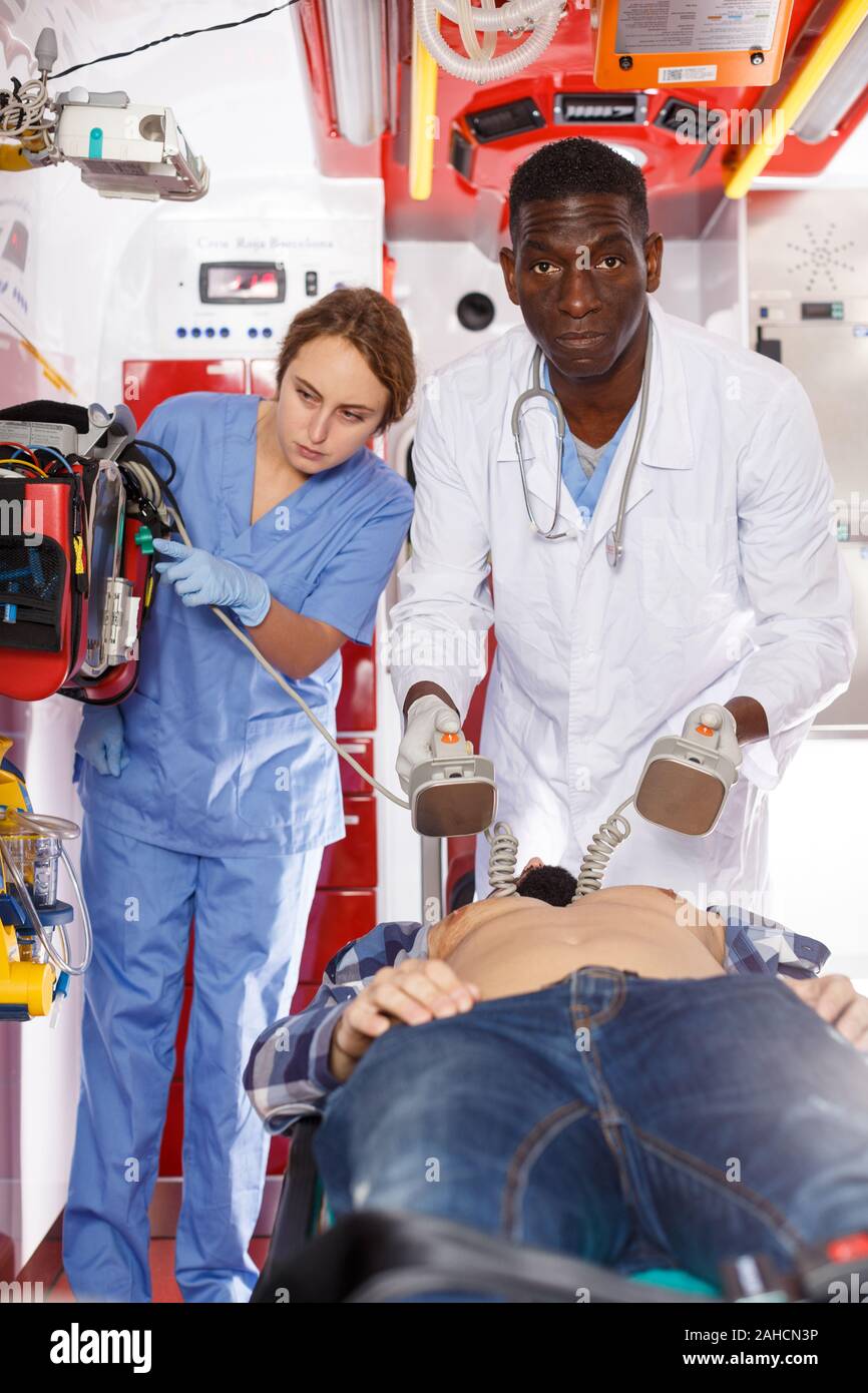 Doctor using defibrillator hi-res stock photography and images - Alamy