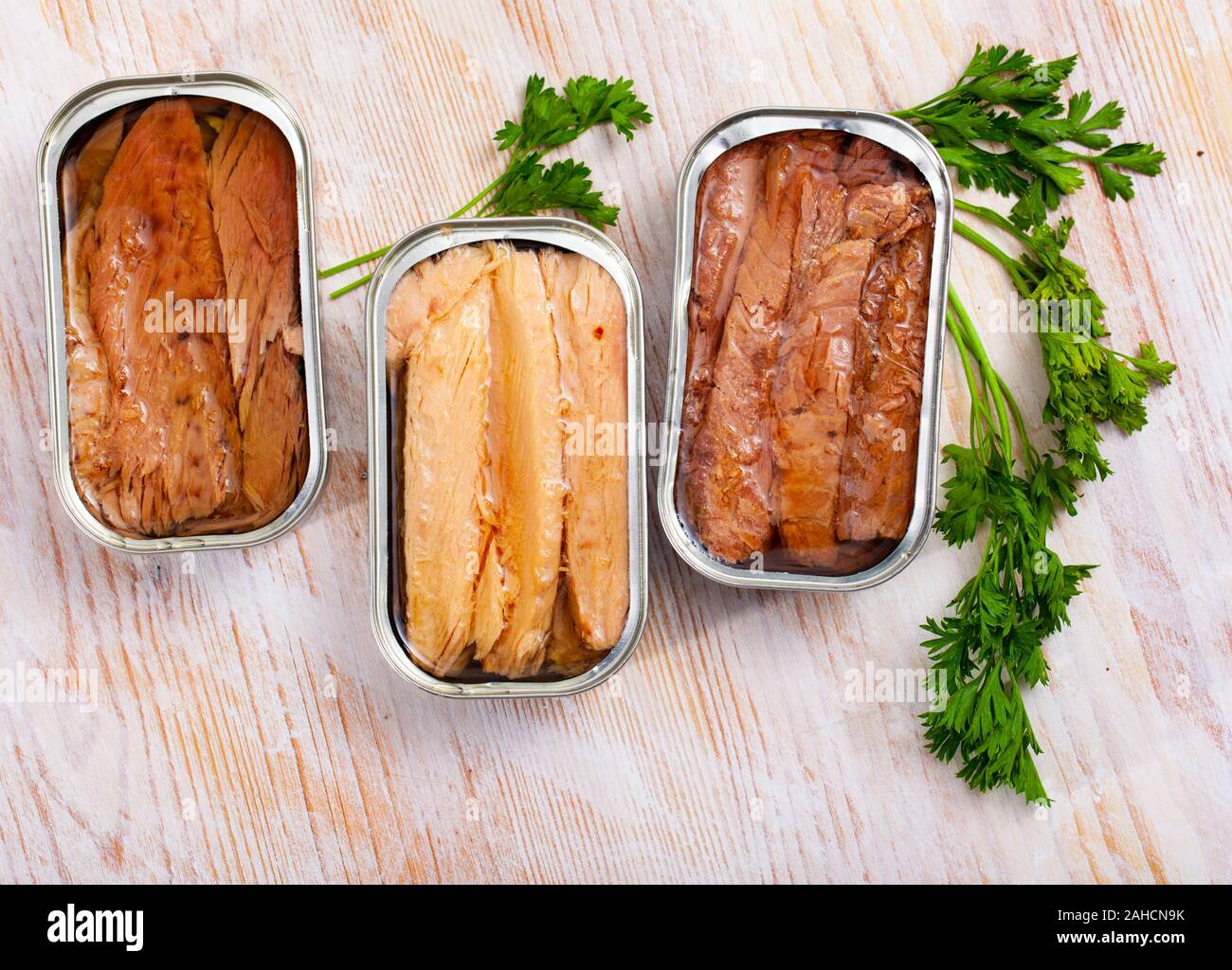Open can of preserved natural fillet of frigate tuna on wooden table ...